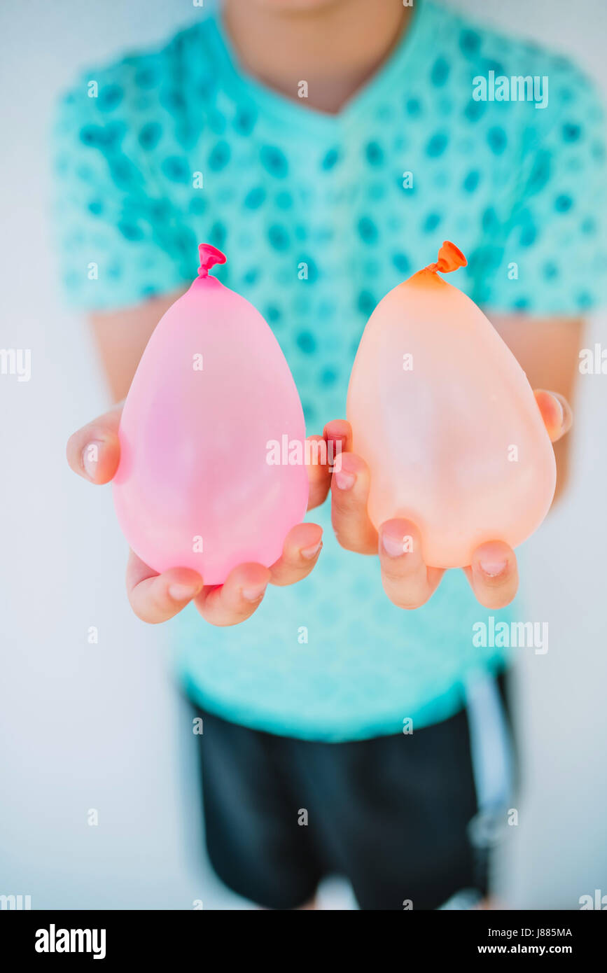 Boy is holding water balloons Stock Photo - Alamy