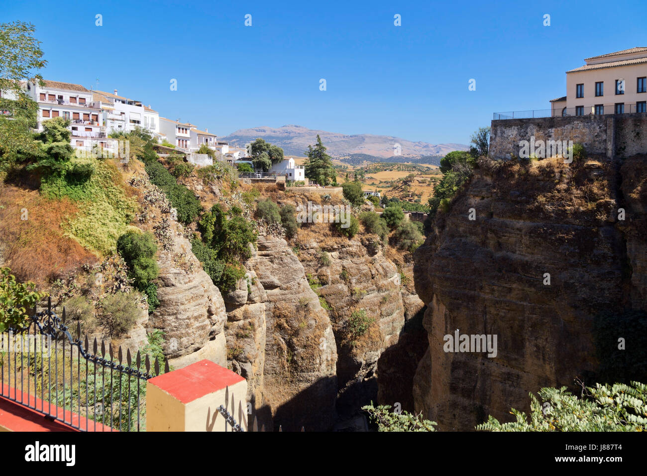 View of the buildings standing on the edge of a cliff in Ronda town ...