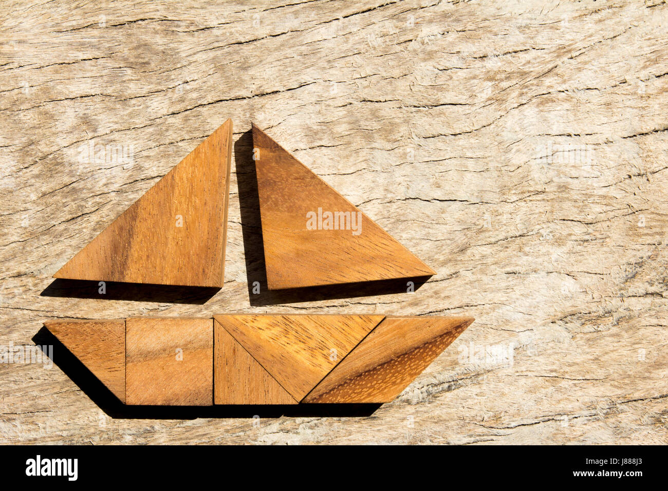 Tangram puzzle in sailing boat on wooden background (Concept for start ...