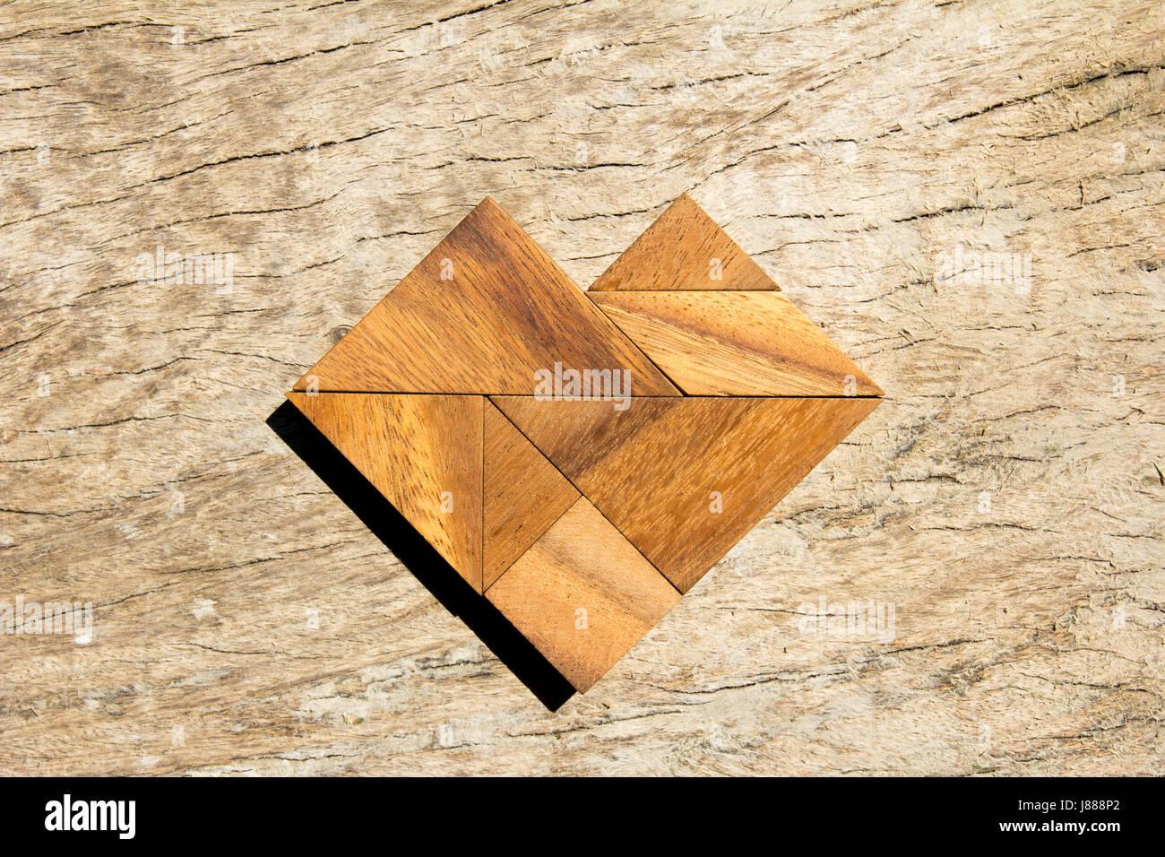 Tangram puzzle in heart shape on wooden background Stock Photo - Alamy
