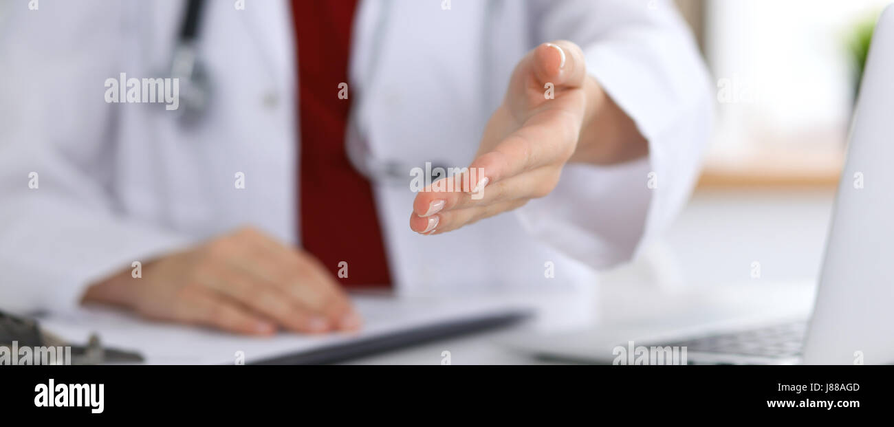 Female medicine doctor offering helping hand in office closeup ...