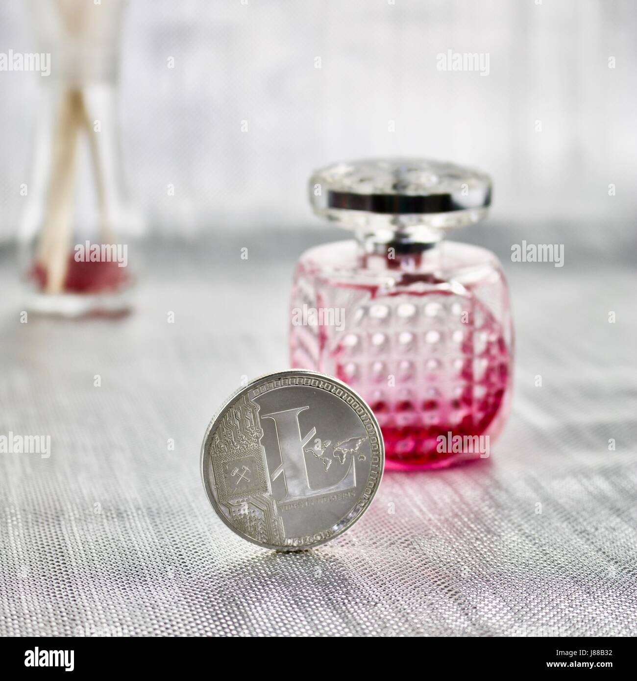 Digital currency physical silver litecoin coin near pink fragrance ...