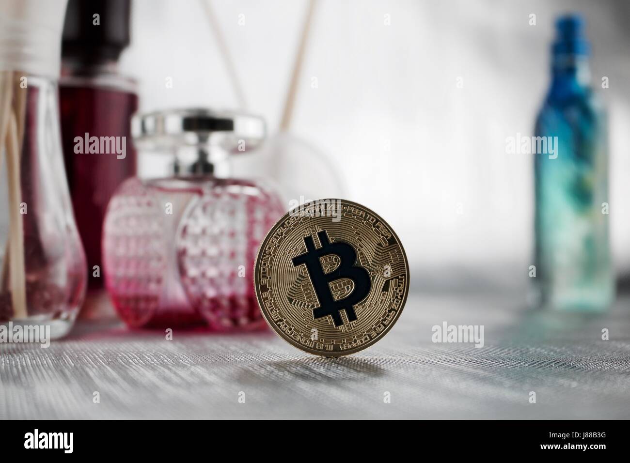 Digital currency physical gold bitcoin coin in pink perfume composition ...