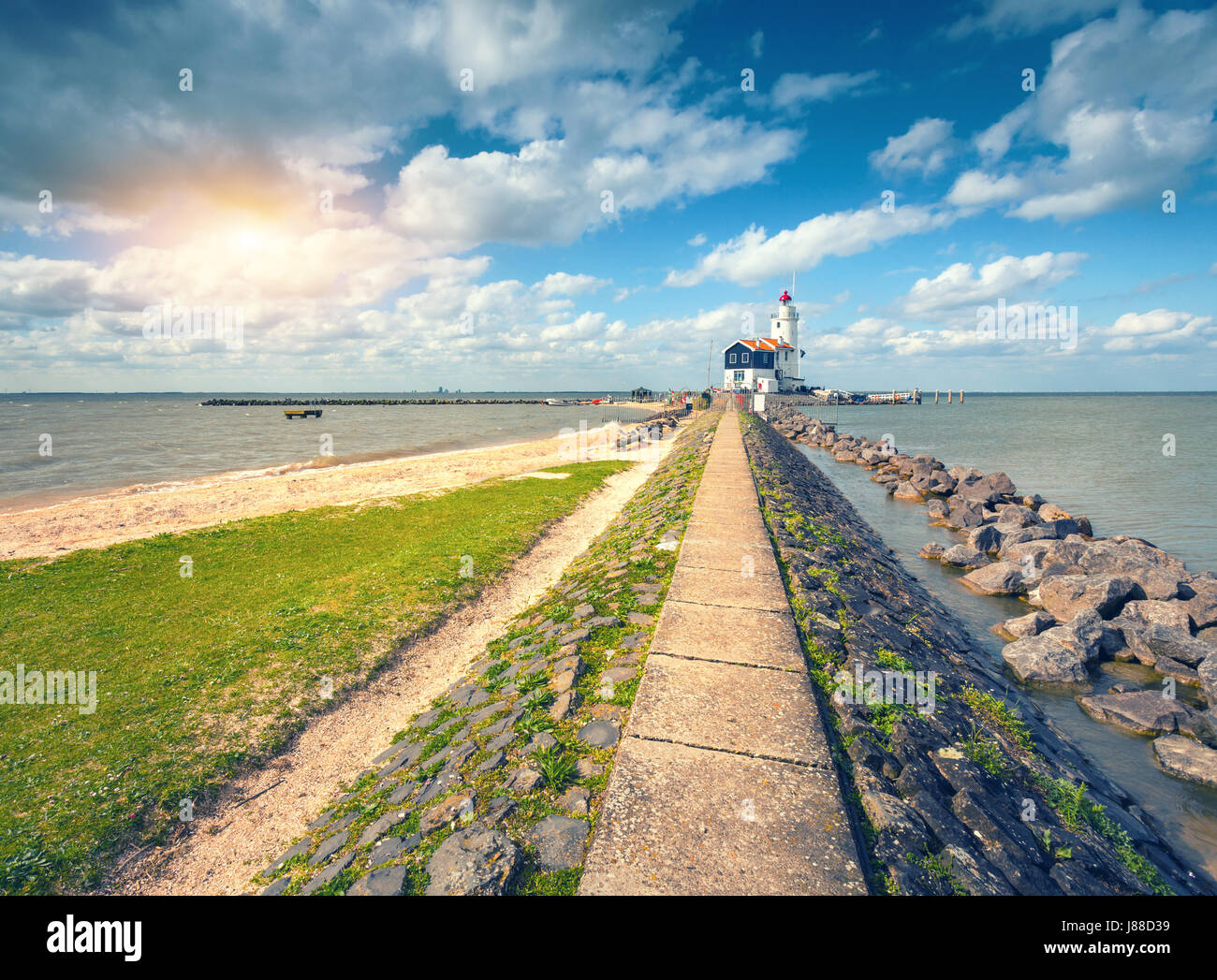 Stone path leading to the lighthouse on the sea coast on the background ...