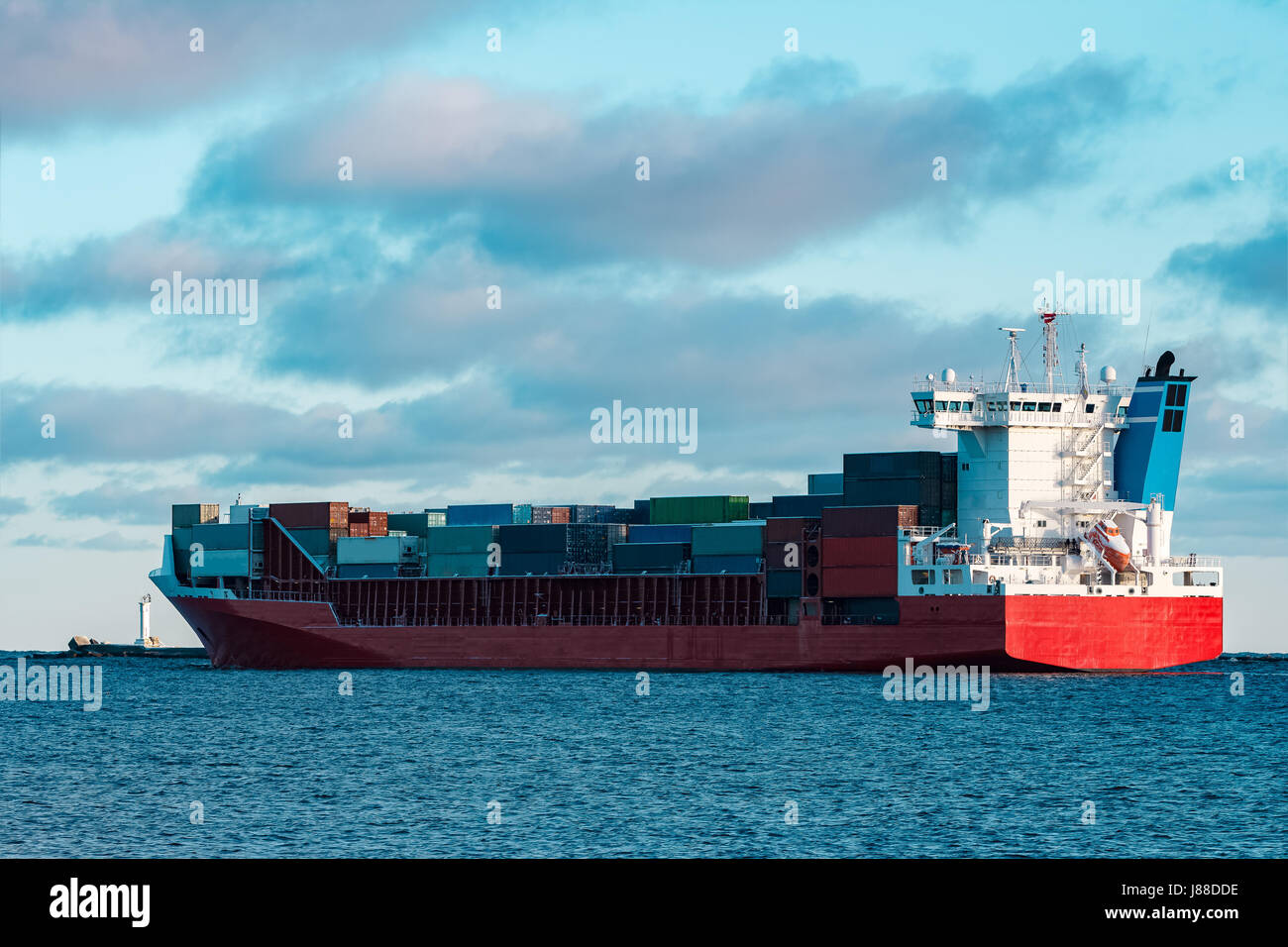 Full red container ship moving in still water Stock Photo - Alamy