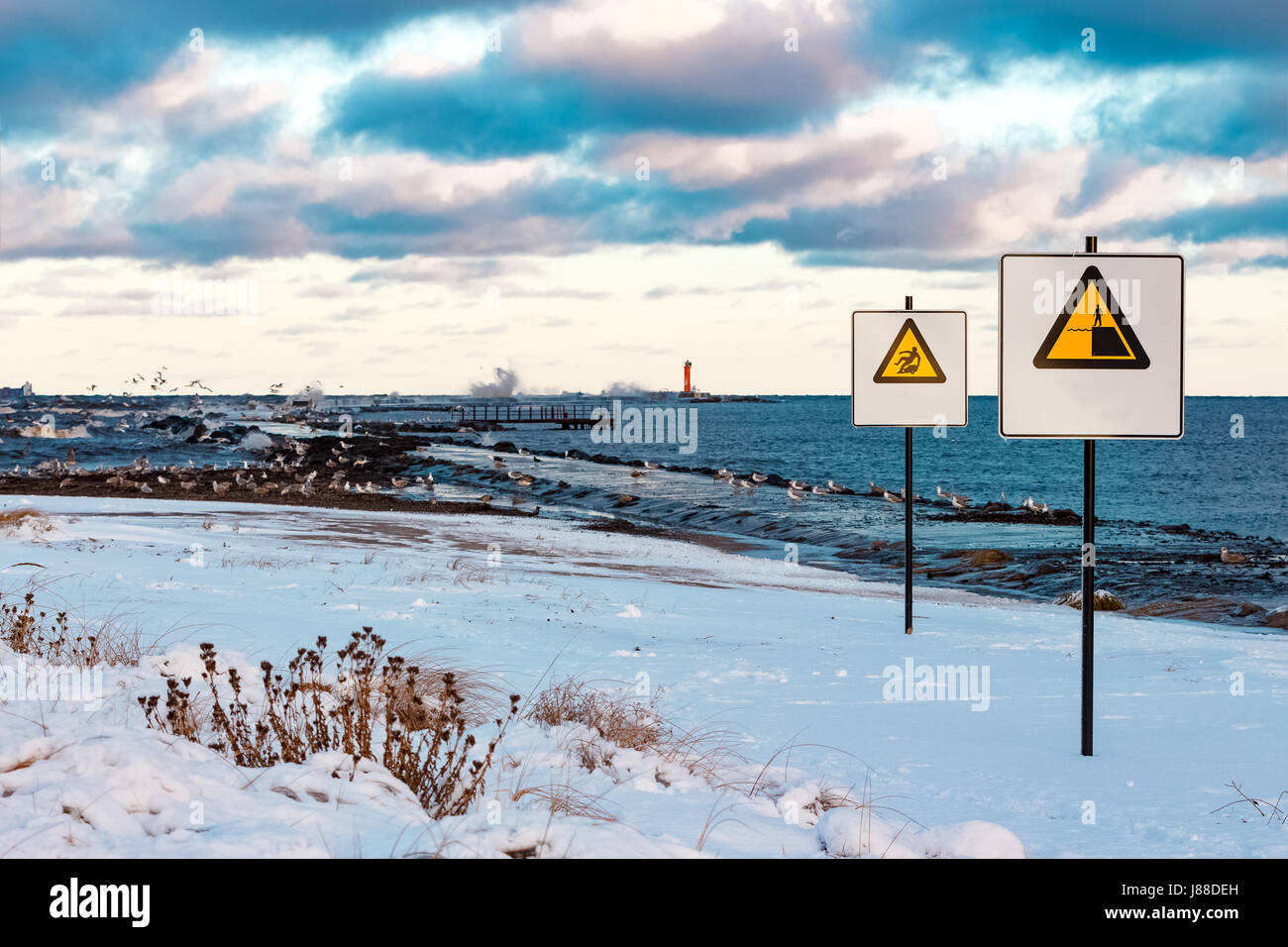 Two yellow warning signs on the winter beach Stock Photo - Alamy