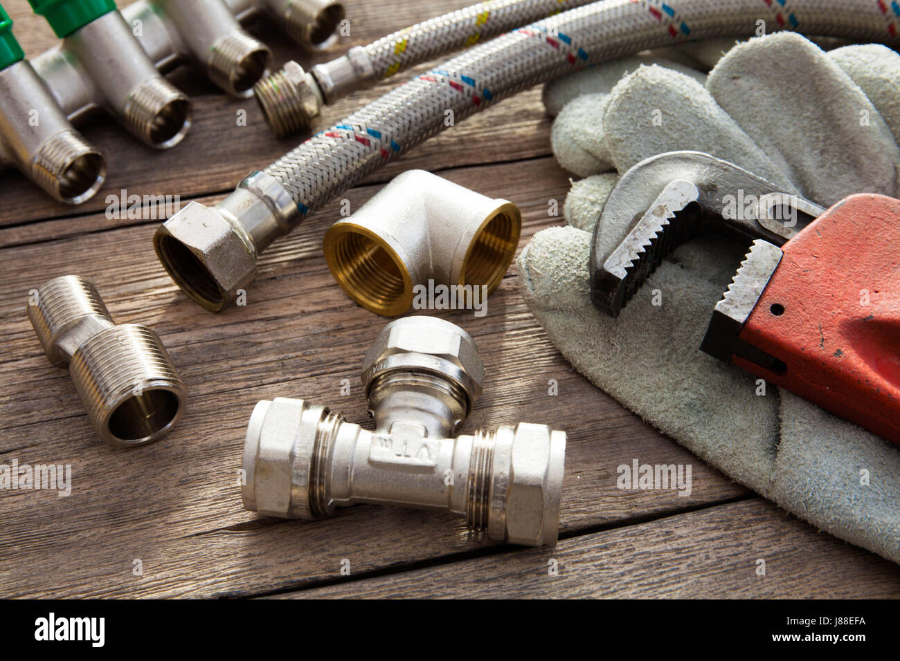 Set of plumbing and tools on the table. Fitting, suede gloves and ...