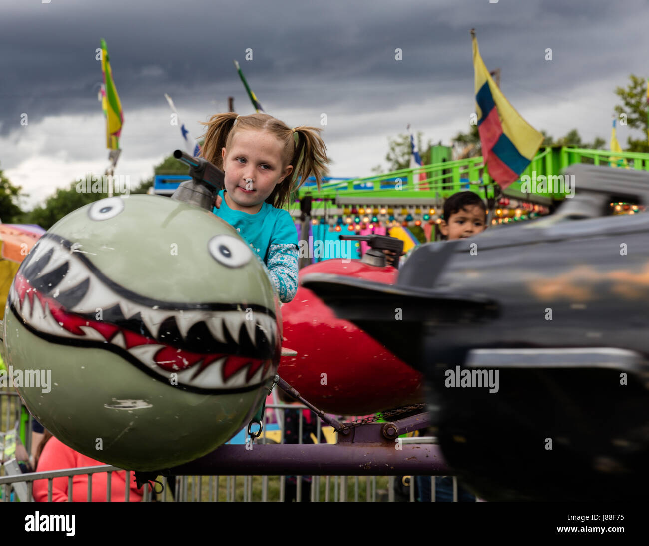 Children having fun on a ride at the county fair Stock Photo - Alamy