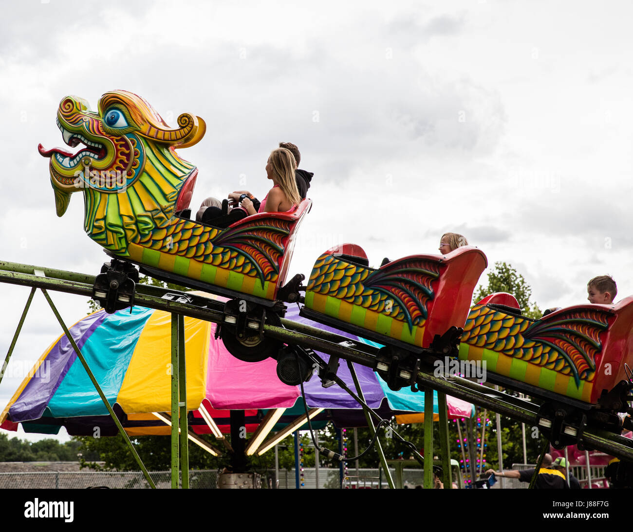 Children and adults enjoying a ride on the midway at the county fair ...