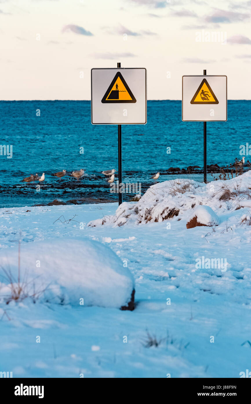 Two yellow warning signs on the winter beach Stock Photo - Alamy