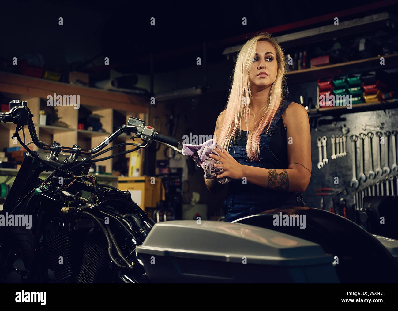 Blond woman mechanic in a motorcycle workshop Stock Photo - Alamy