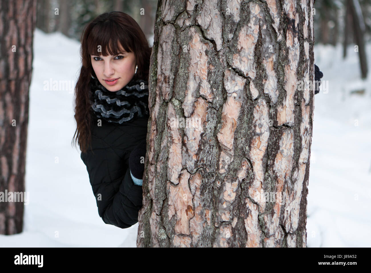 young sympathetic woman hiding behind a tree Stock Photo - Alamy