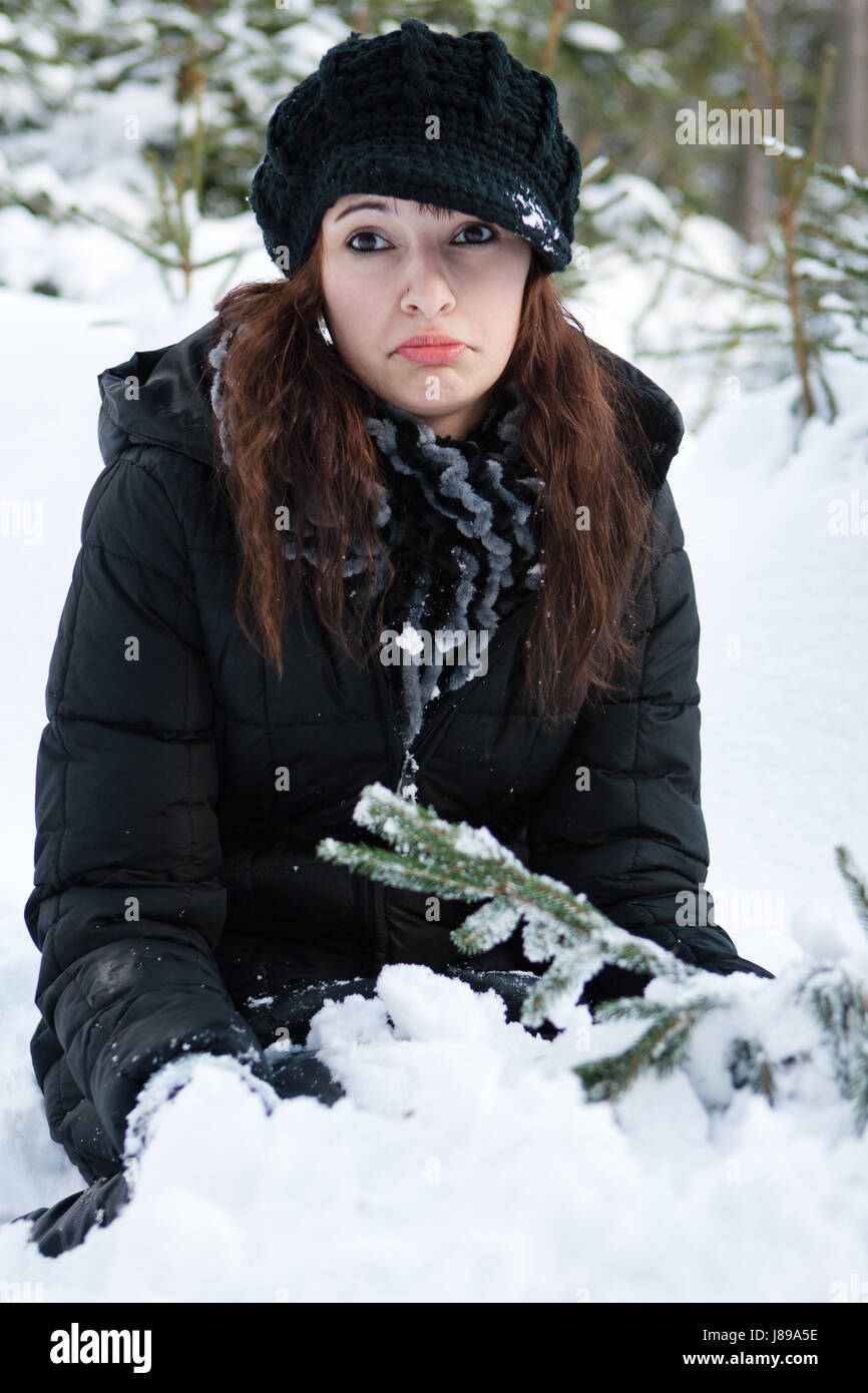 young sympathetic woman sitting in the snow and looks sad Stock Photo ...