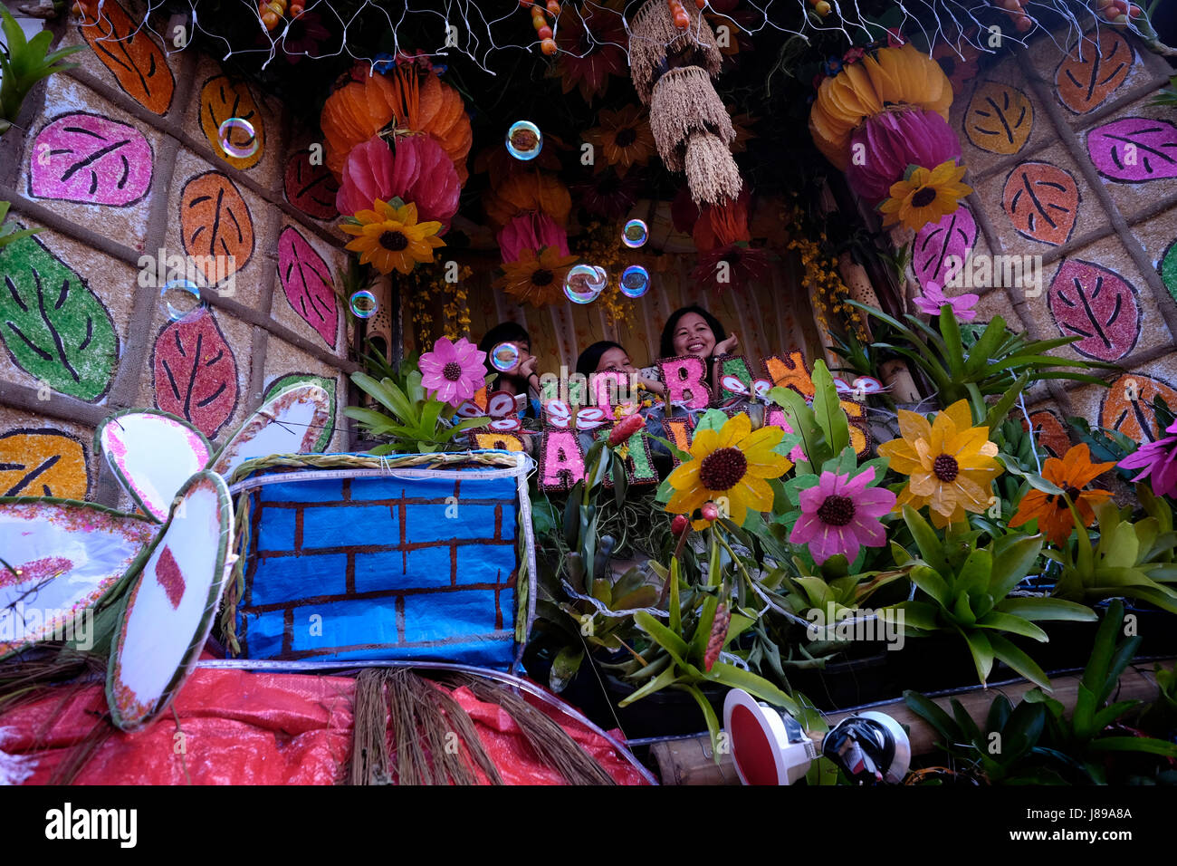 Filipino women peeping out of a window of a house decorated with ...