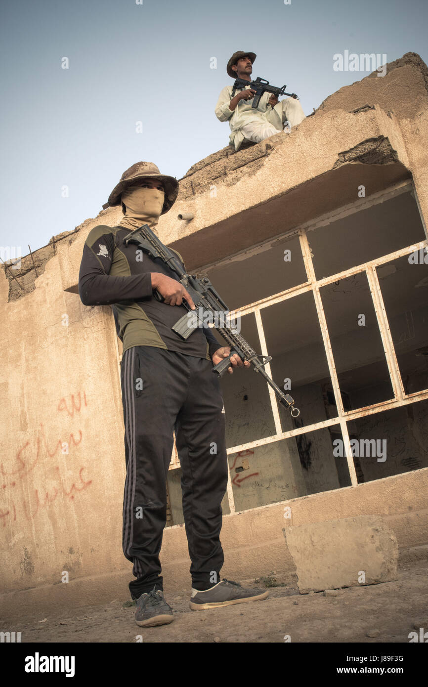 Two Iraqi special operations forces soldiers stand guard as the ...