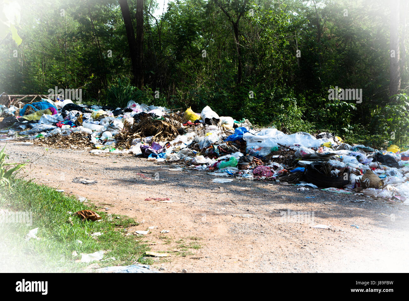 Pile of domestic garbage near the country road on nature background ...