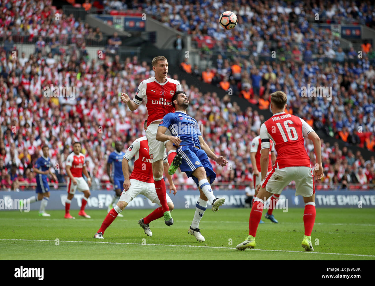 Arsenal's Per Mertesacker and Chelsea's Diego Costa jump for possession ...