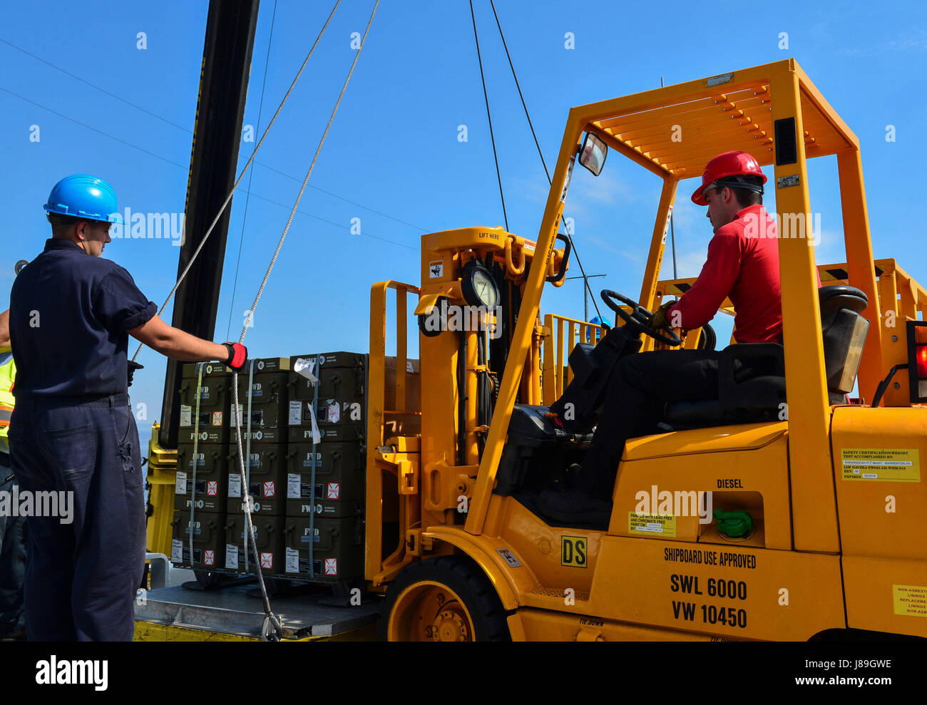 An Aviation Ordnanceman operates a forklift on the flight deck of USS ...