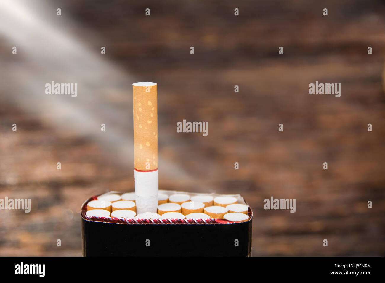 cigarette and cigarette box with sun ray on wooden background Stock ...