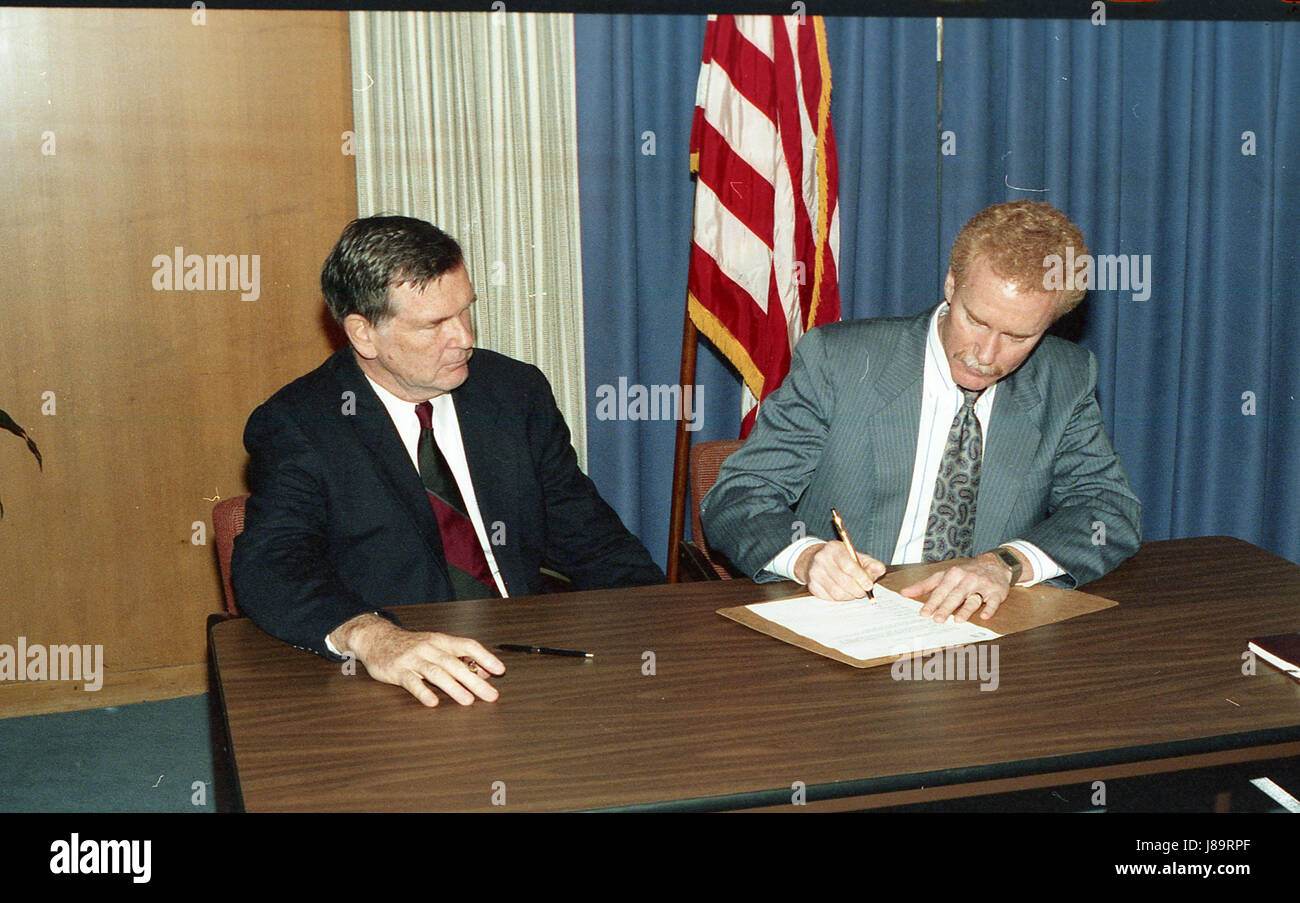 men sitting signing papers Stock Photo - Alamy