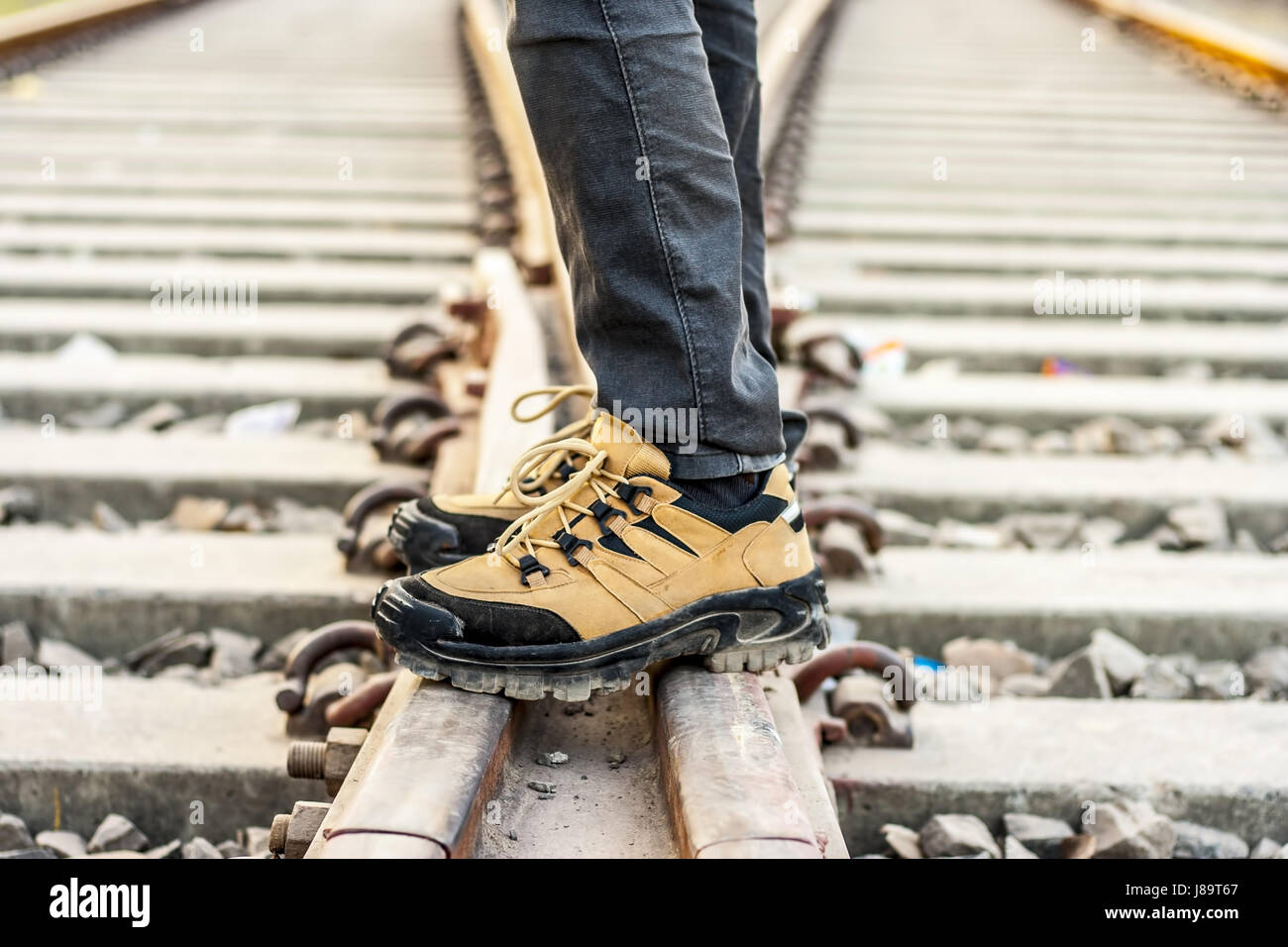 A boy standing on railway tracks wearing leather shoes Stock Photo - Alamy