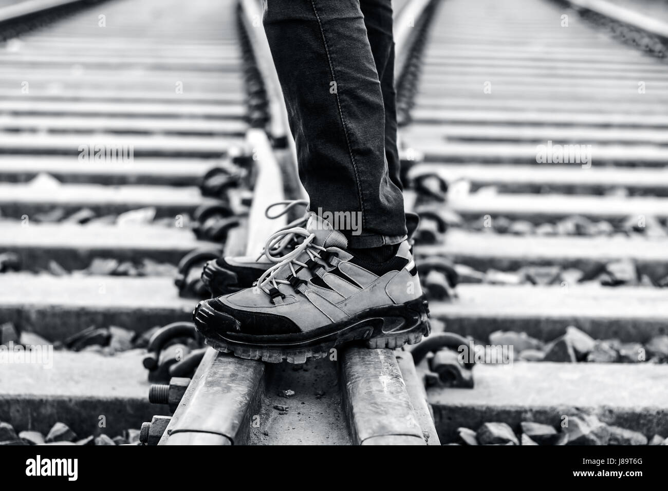A boy standing on railway tracks wearing leather shoes Stock Photo - Alamy