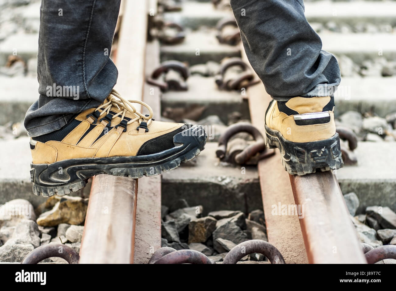 A boy standing on railway tracks wearing leather shoes Stock Photo - Alamy