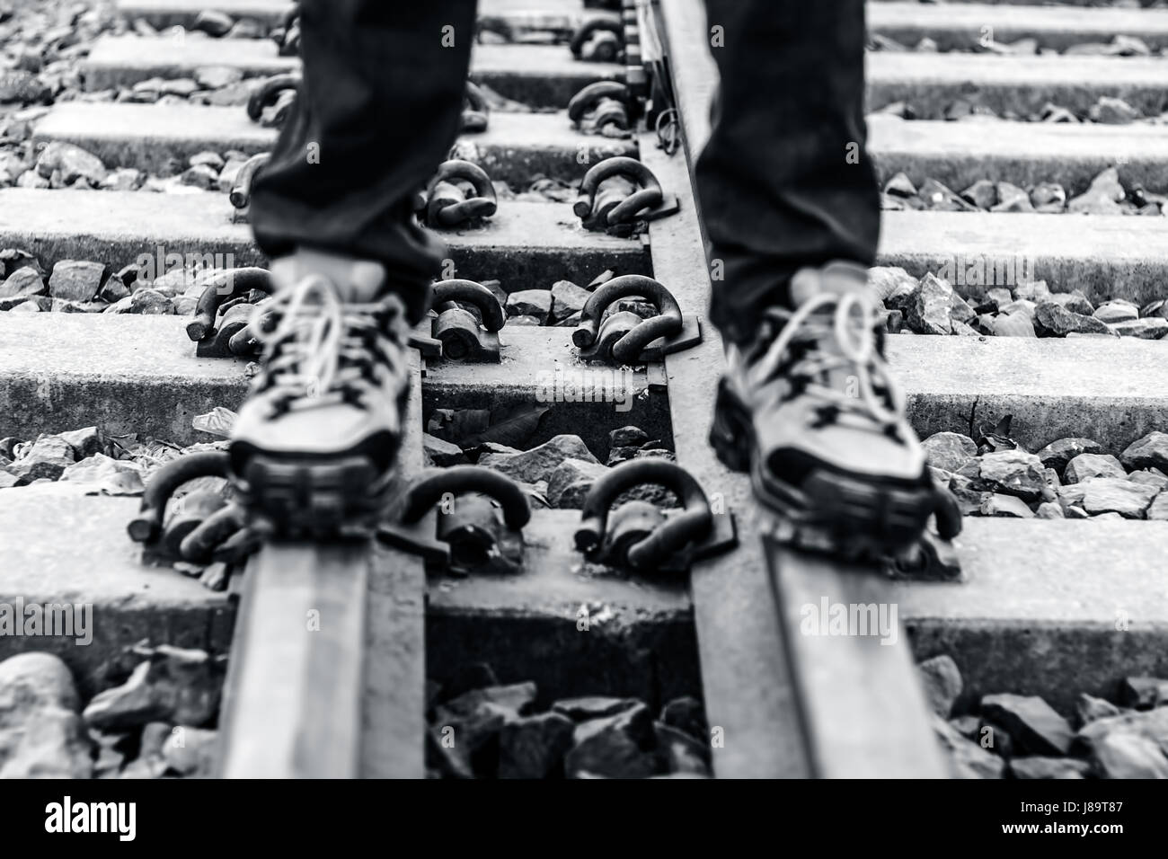 A boy standing on railway tracks wearing leather shoes Stock Photo - Alamy