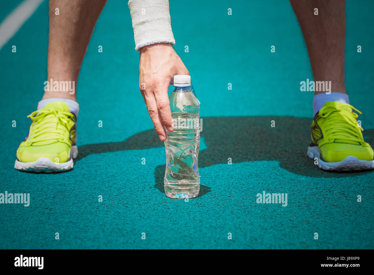 Close up shoot of male jogger hand holding plastic bottle of water on ...