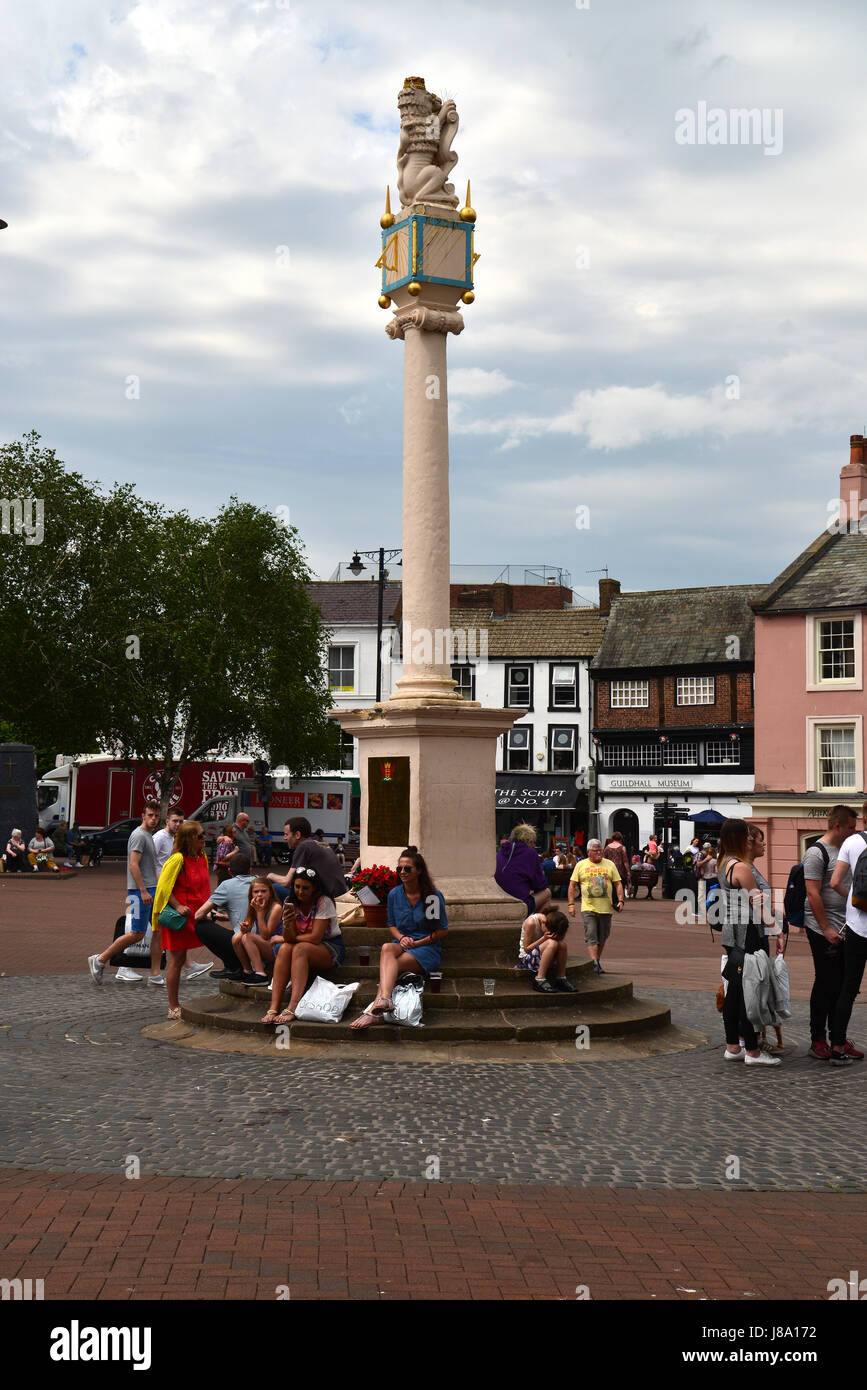 people enjoying the sun and a pint while sitting on Carlisle cross ...