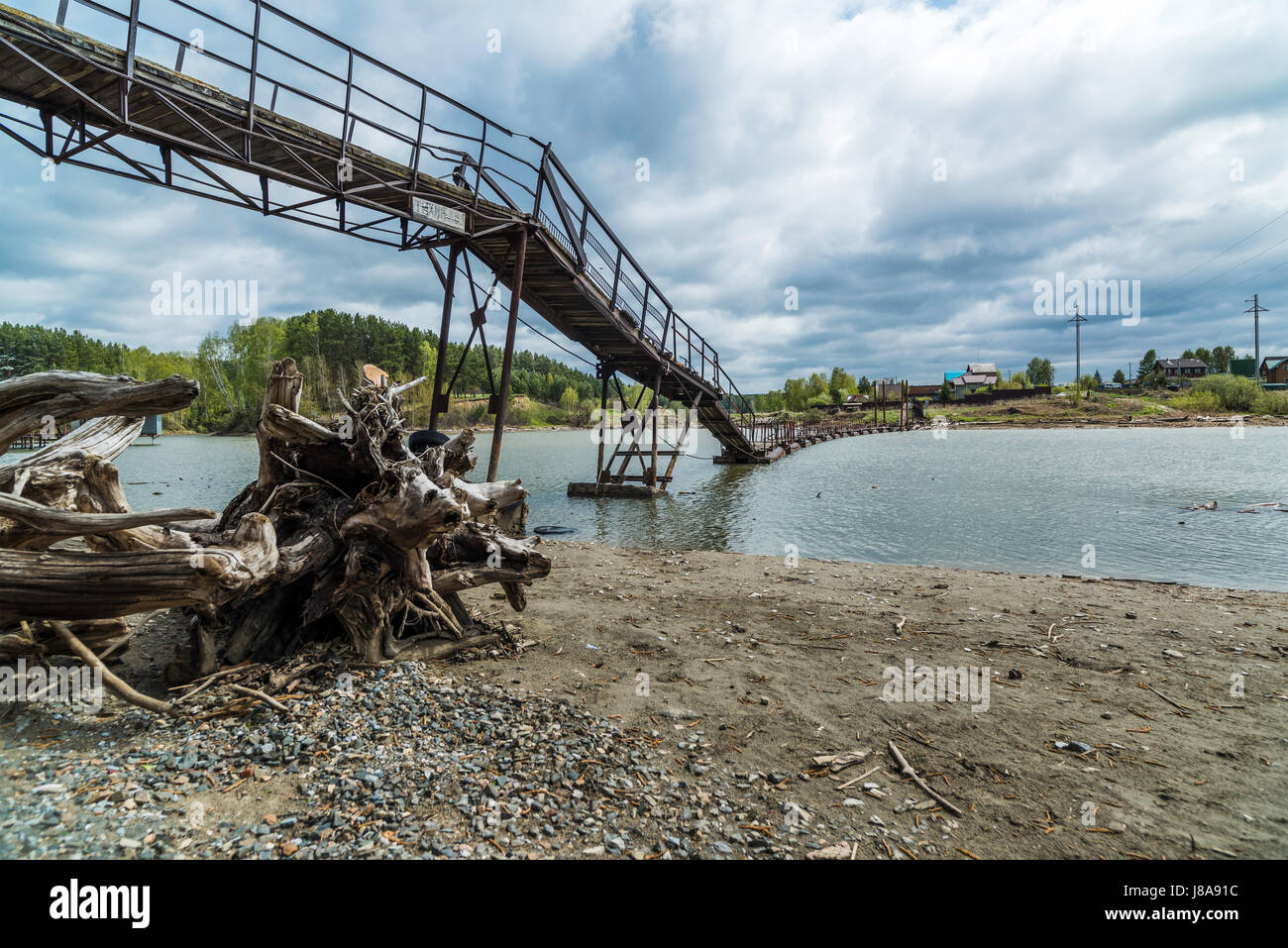 An old pontoon bridge across the river. Russia, Siberia, the Razdelnaya ...