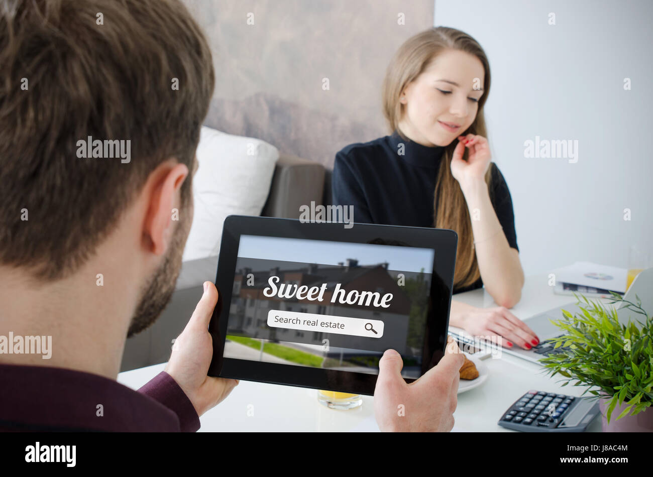 Young couple looking on the internet your own home. couple house ...