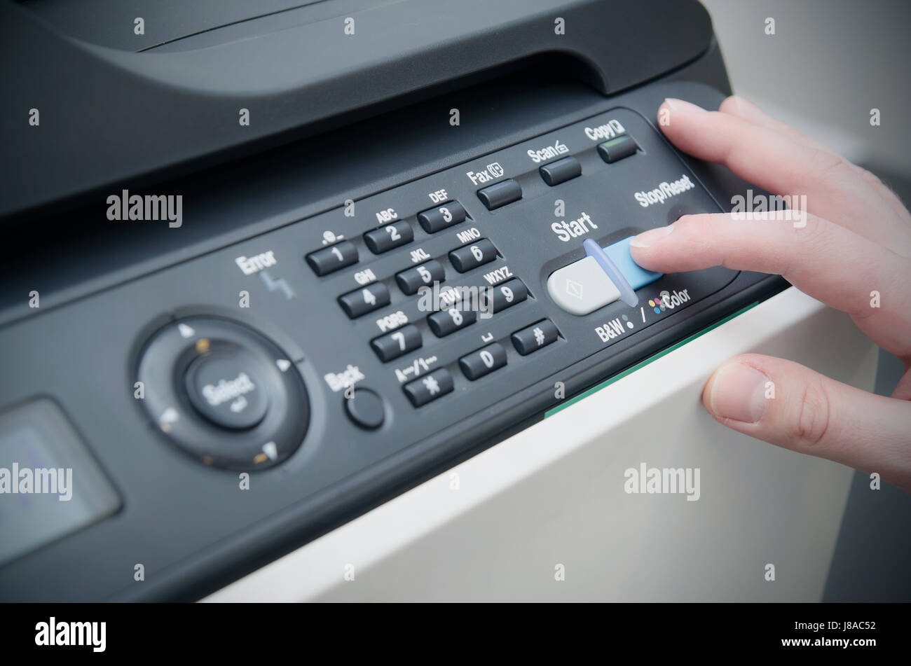 Man holding finger on start button of laser printer Stock Photo - Alamy