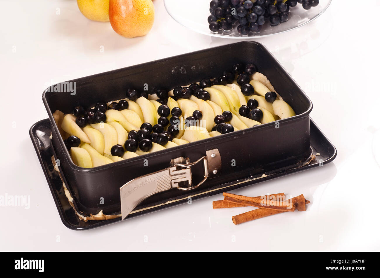 square springform pan with cake batter,topped with pears and grapes ...