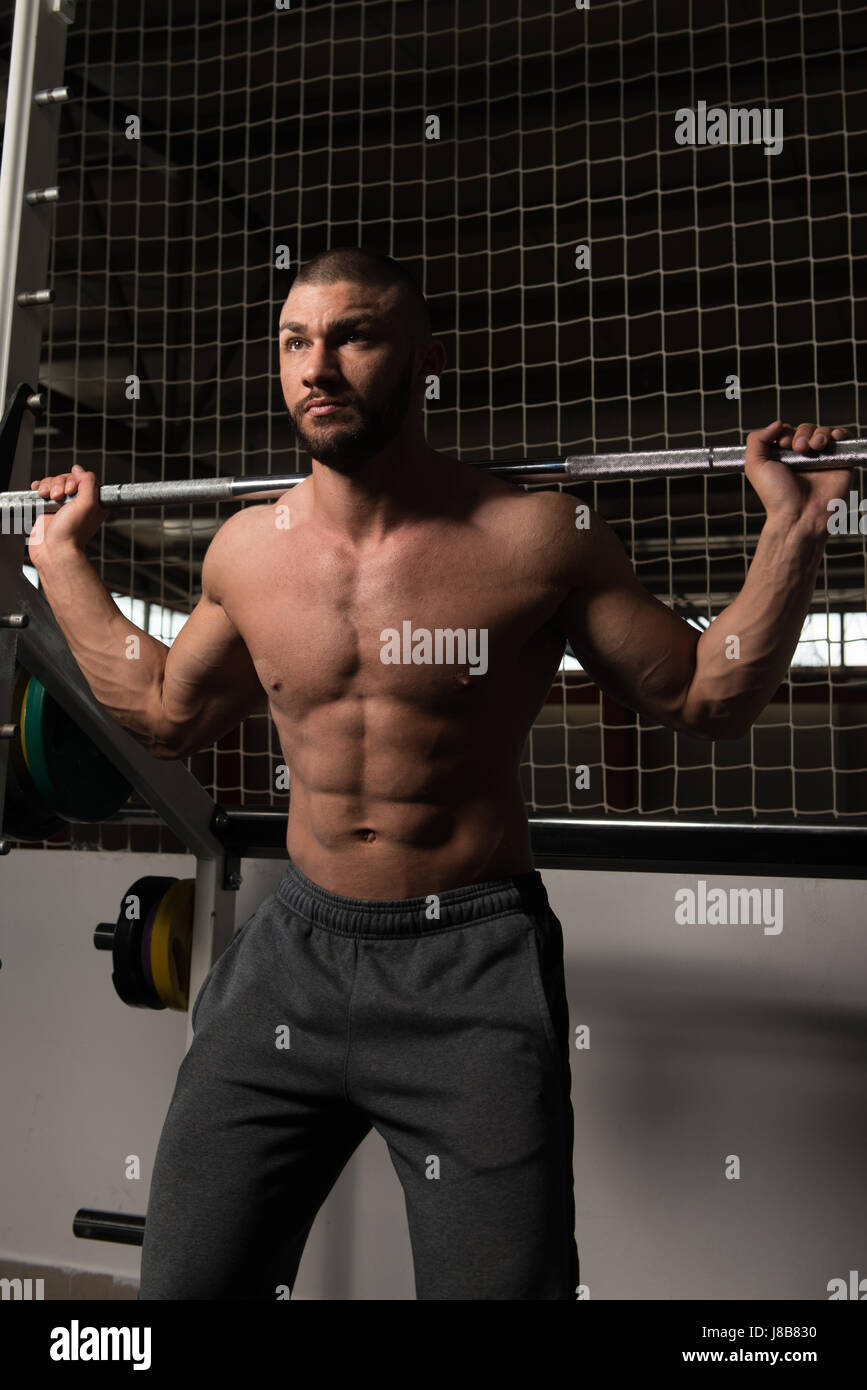 Man Working Out Legs With Barbell In A Gym - Squat Exercise Stock Photo ...