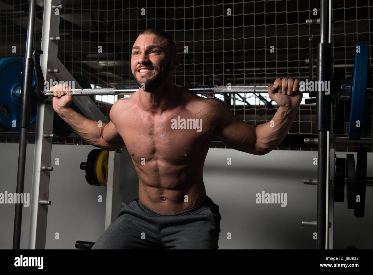Man Working Out Legs With Barbell In A Gym - Squat Exercise Stock Photo ...