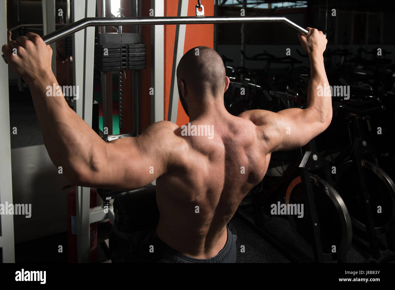 Handsome Bodybuilder Doing Heavy Weight Exercise For Back On Machine ...