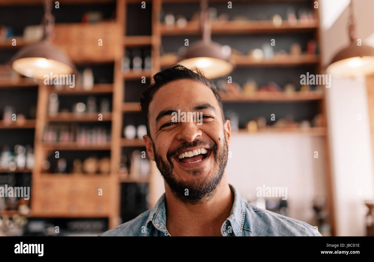 Close up portrait of happy young man laughing in a cafe. Young ...