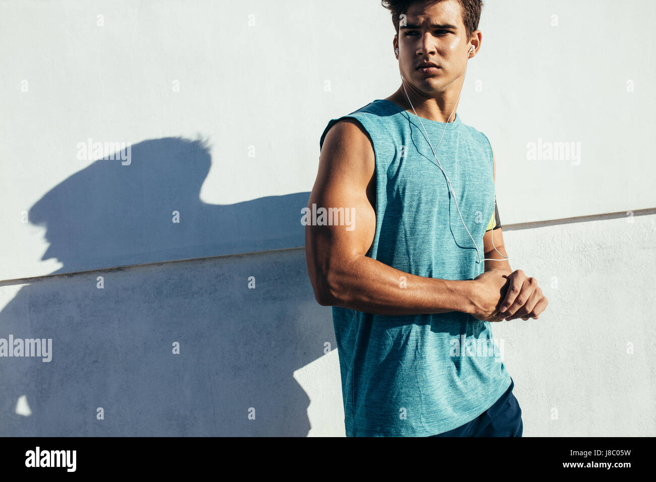 Shot of muscular young man relaxing after workout. Male runner man ...