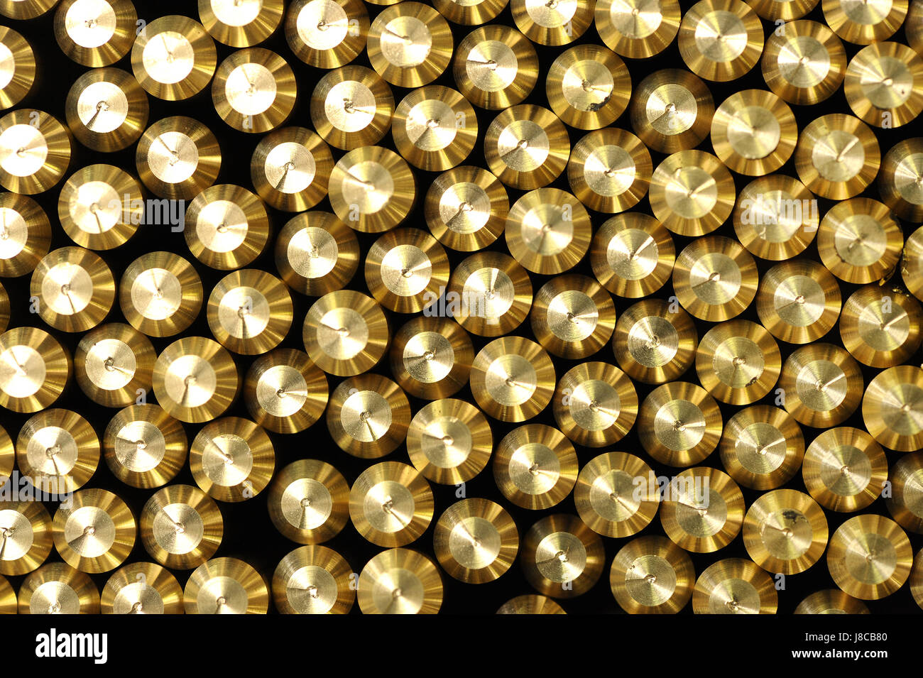 Background pattern of the ends of shiny bevelled brass rods for use as ...