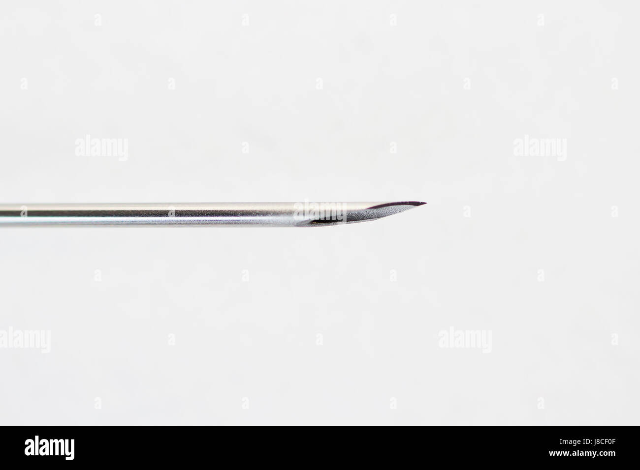Macro shot of a medical needle from a syringe on a white background ...