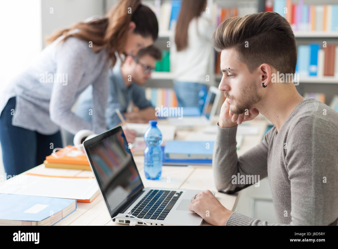 Group of college students doing homework and studying together, they ...