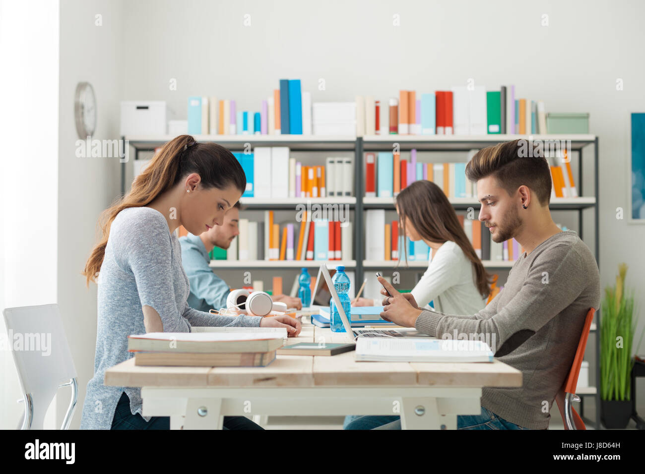 Group of college students doing homework and studying together, they ...