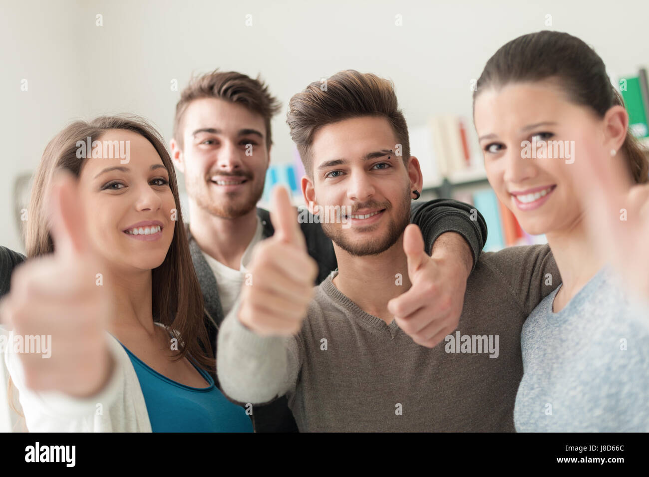 Cheerful group of friends posing together with thumbs up, satisfaction ...