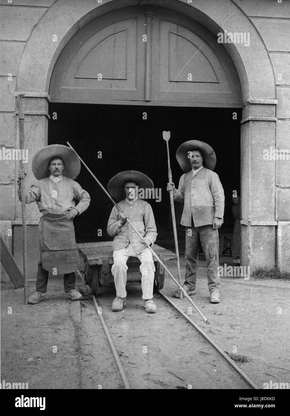 The image depicts iron furnace workers in Eisenerz around 1910 ...