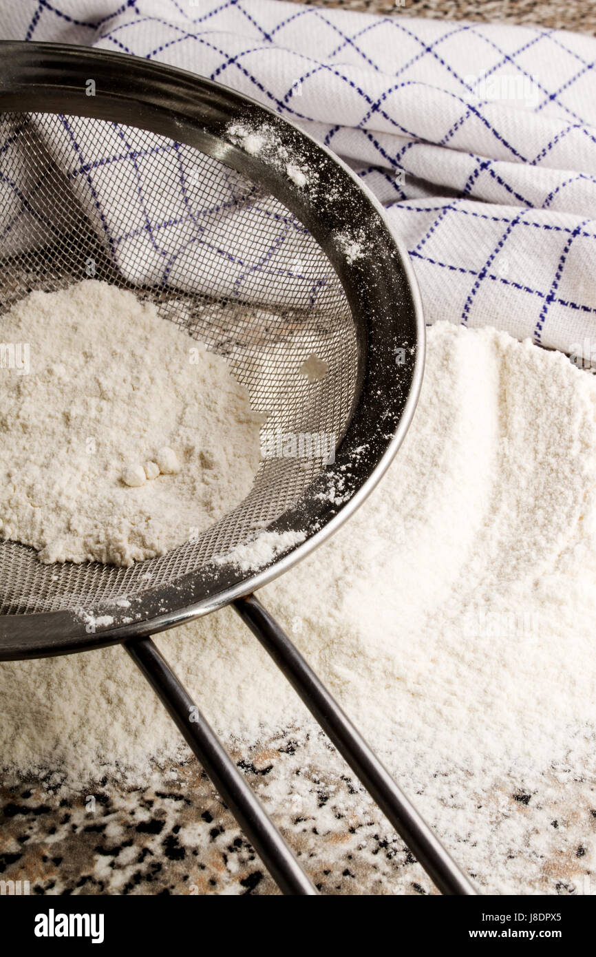 flour is sieved before baking with a metal sieve Stock Photo - Alamy