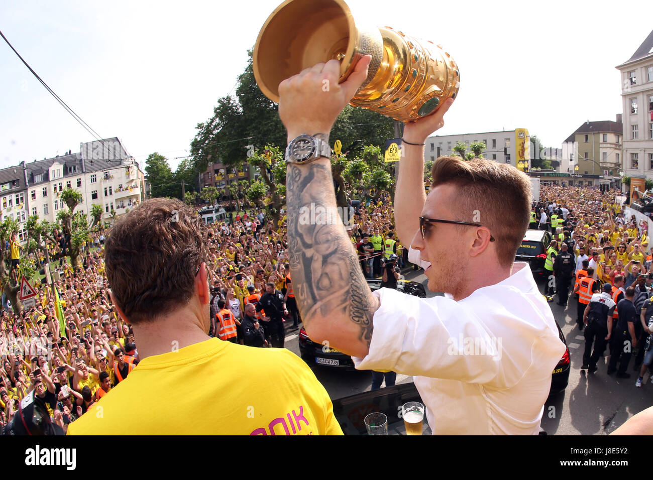 Marco Reus (l) holds the cup on the team truck in Dortmund, Germany, 28 ...