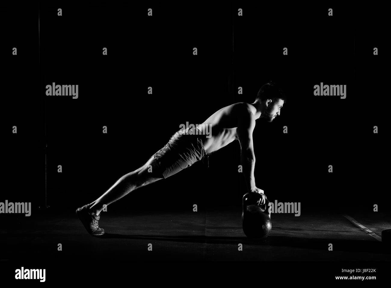 Fitness training. Man doing push ups exercise using dumbbells or ...