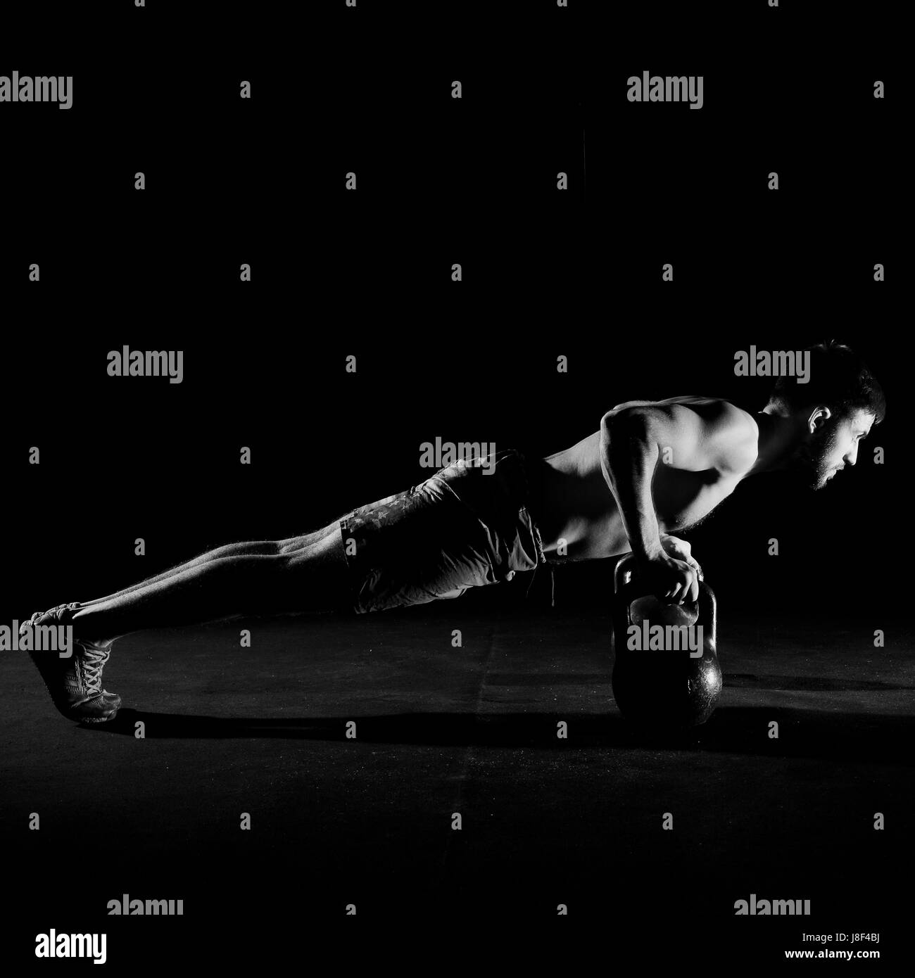 Fitness training. Man doing push ups exercise using dumbbells or ...