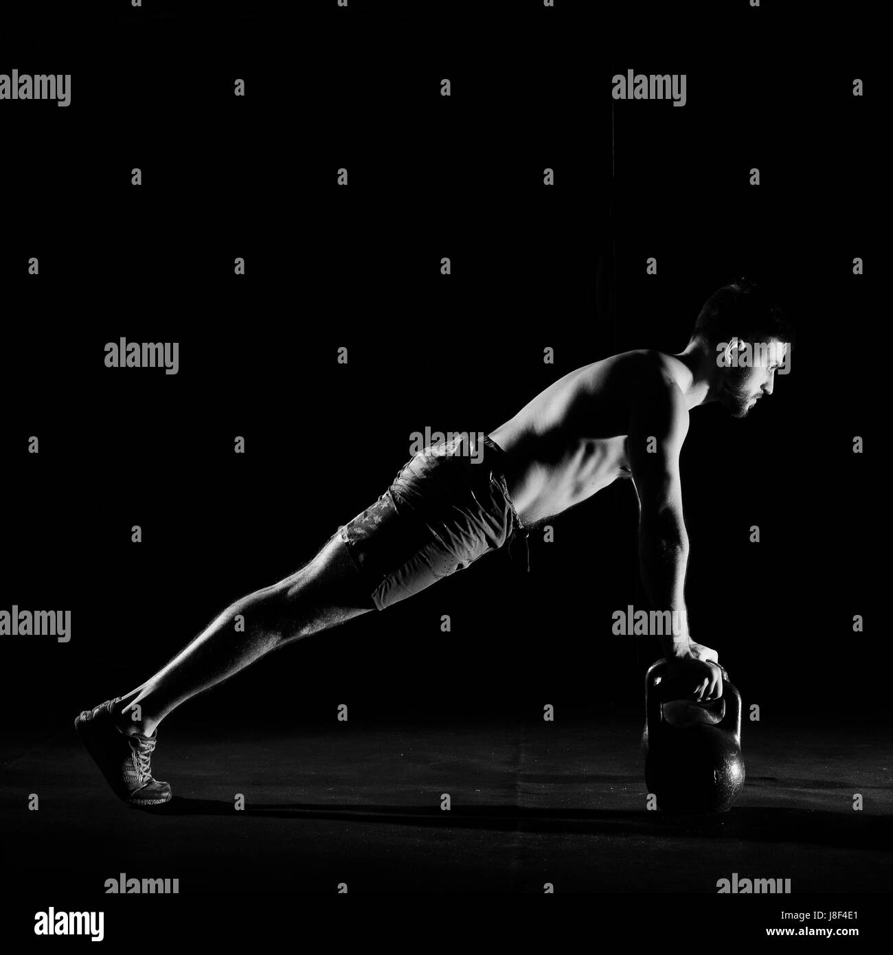 Fitness training. Man doing push ups exercise using dumbbells or ...